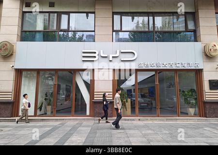 Pedestrians pass by a BYD Auto flagship store on Nanjing West Road in ...