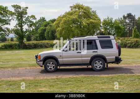 Modified silver Land Rover Defender 110 LWB climbing a steep dirt hill ...