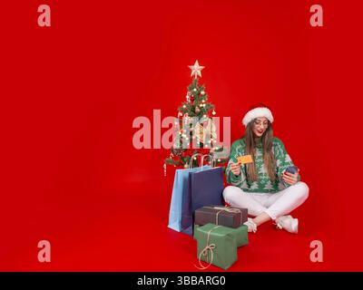 Girl sit near christmas tree. Waiting for christmas. Wishing everyone ...