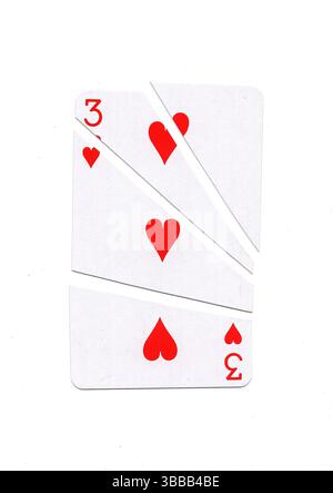 A vintage playing card cut into sharp pieces on a white background ...
