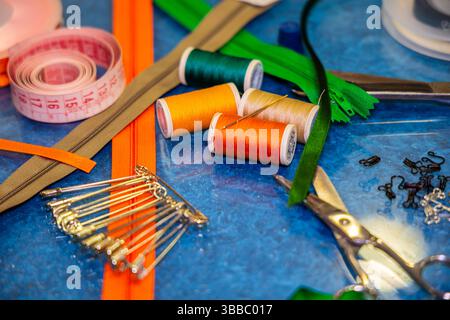 Thread spools, measuring tape and zippers on beige background Stock ...