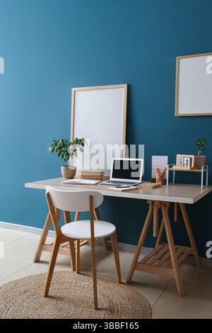 Blank posters and workplace with laptop in living room Stock Photo - Alamy