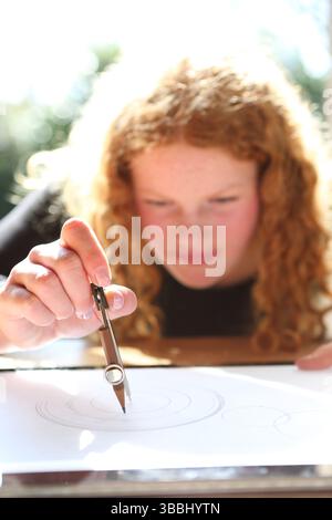 Girl drawing circle with pair of compasses and pencil maths skills ...