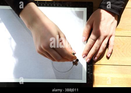 Girl drawing circles with pair of compasses and pencil maths skills ...