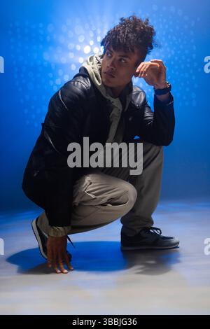 African American male model crouching and posing to the camera on white ...
