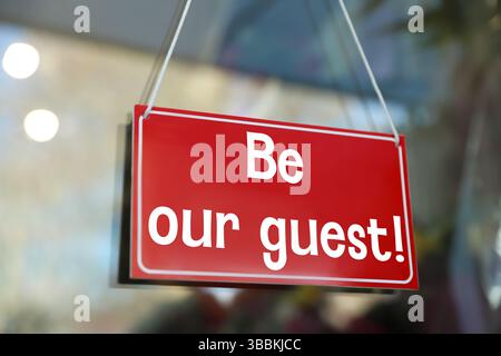 Be Our Guest sign hanging on glass door outdoors Stock Photo - Alamy