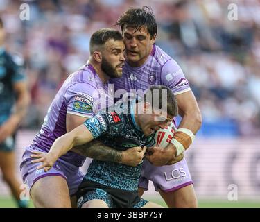 Kaide Ellis of Wigan Warriors is tackled during the Betfred Super ...
