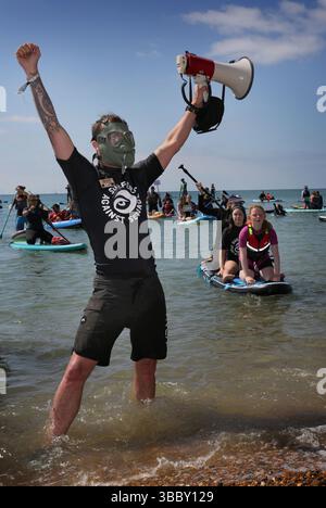 May 17, 2025, Brighton, England, UK: Protesters sit on the beach with ...