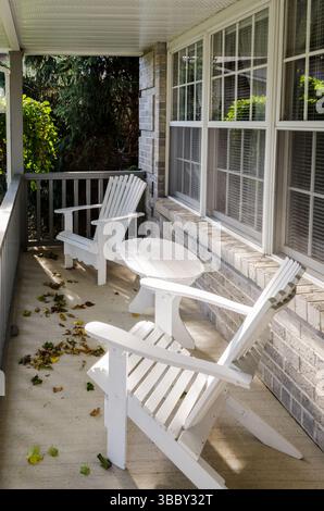Adirondack chairs on the deck of a covered pedestrian bridge, facing a ...