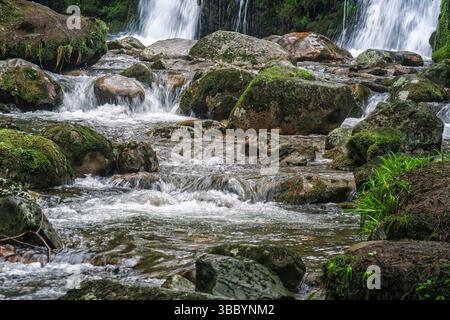 Triple waterfall cascading into a pool, flowing wild through Glenmalure ...