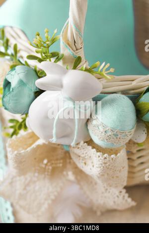 Wicker basket with Easter eggs and ceramic rabbit figure on white ...