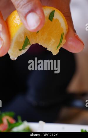 hands squeezing lemon juice onto calamari strips Stock Photo - Alamy
