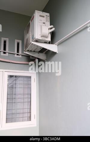 Close-up of an air conditioner outdoor unit installed outside an old ...