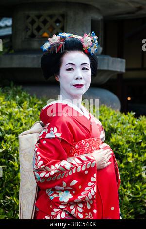 Japan, Kyoto. Japanese mature Geisha, maiko, turning her face to look ...