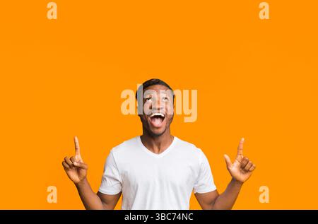 Excited Guy Pointing Fingers Up Standing On Orange Background, Studio ...