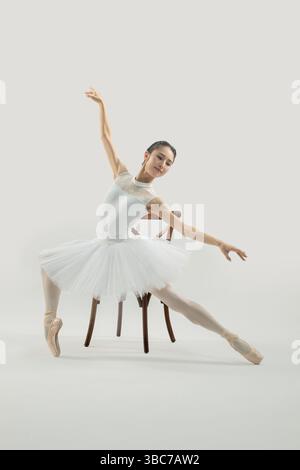 a ballet dancer leaning on a chair while dancing Stock Photo - Alamy