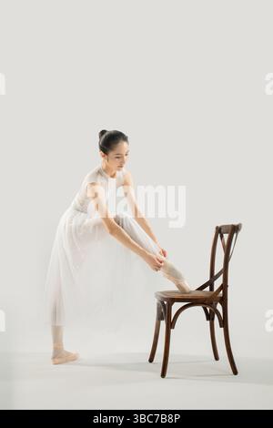 a ballet dancer leaning on a chair while dancing Stock Photo - Alamy
