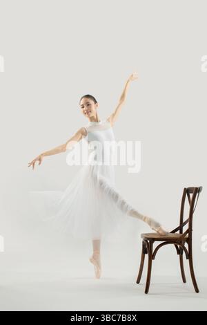 a ballet dancer leaning on a chair while dancing Stock Photo - Alamy