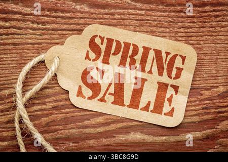 Spring sale sign - red stencil text on a yellow paper price tag against ...