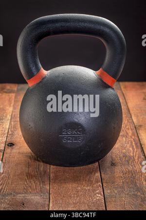 iron kettlebell on a rustic wood background against grunge wall with a ...