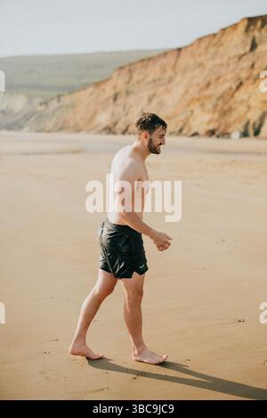 Young handsome man shirtless wearing swimsuit and swim cap over ...