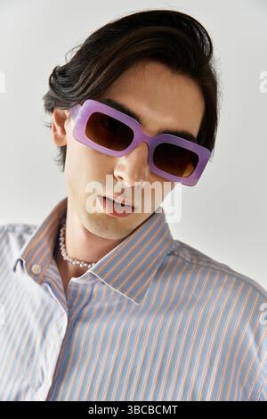 A young non binary individual poses stylishly on a stool, expressing ...