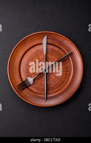 Empty plate with devices in the form of clock hands as a conceptual ...