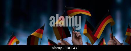 Germany flags in their hands on a blurred urban background Stock Photo ...