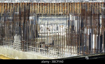 A construction site with large concrete pillars and power lines under a ...