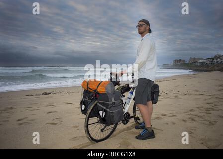 Long Distance Cyclist with Bicycle by Ocean Stock Photo - Alamy