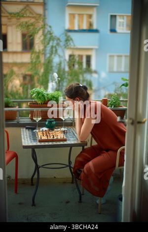 Woman at home playing chess alone Stock Photo - Alamy