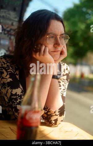 Pensive woman rests seated on sofa with mobile phone Stock Photo - Alamy