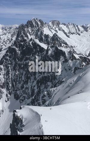 Mountaineers on the rocky summit ridge with the first snow in autumn ...