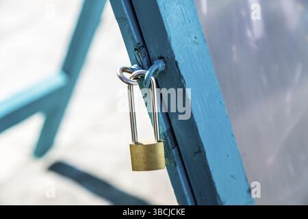 long pad lock hanging on a blue wooden frame Stock Photo - Alamy