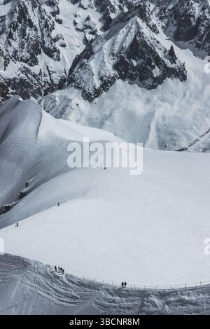 Mountaineers on the rocky summit ridge with the first snow in autumn ...