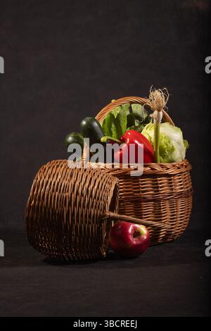 Wicker basket with various colorful vegetables. Fresh red tomatoes in ...