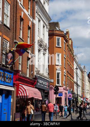 People walking along Old Compton Street in the late afternoon sunlight ...
