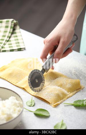 Woman cutting ravioli at light table, closeup Stock Photo - Alamy