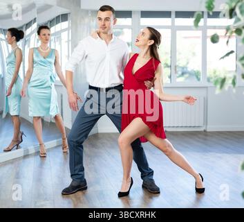 Couple in stage costumes learns tango dancing during individual lesson ...