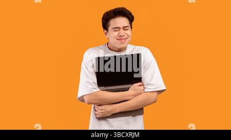 Technology Lover. Excite asian guy hugging personal computer Stock ...