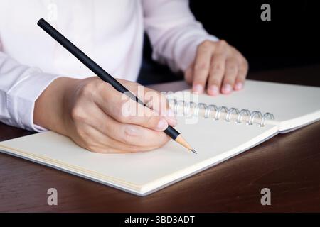 Human hand using pen to write down short note on notebook Stock Photo ...