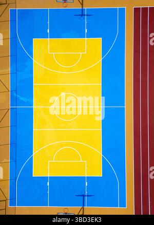 An aerial shot of a yellow field with symmetrical lines and a road on ...