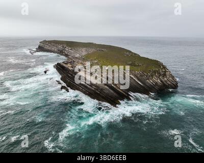 Side view of isolated Baleal islet with steep geological formations ...