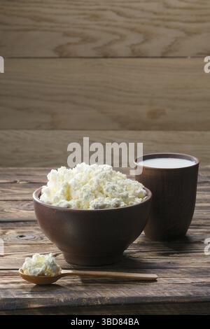 organic cottage cheese on a clay plate, sour cream in a small bowl on ...