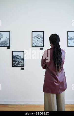 Woman observing photographs on display in photo gallery Stock Photo - Alamy