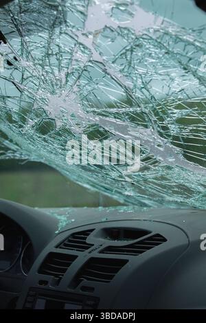Damaged car interior showing cracked windshield and green-tinted glass ...