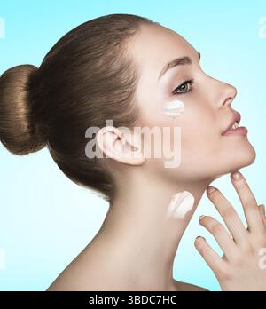 Beautiful model applying cosmetic cream treatment on her face Stock ...