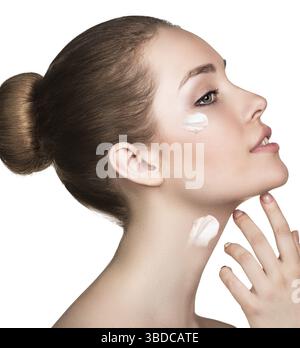 Beautiful model applying cream on face Stock Photo - Alamy