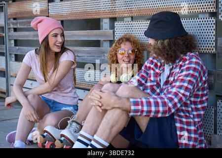 Happy friends are having fun with skates and longboards at straight ...