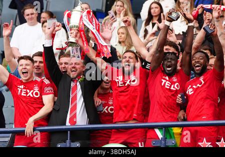 Aberdeen's Graeme Shinnie lifts the trophy with manager Jimmy Thelin ...